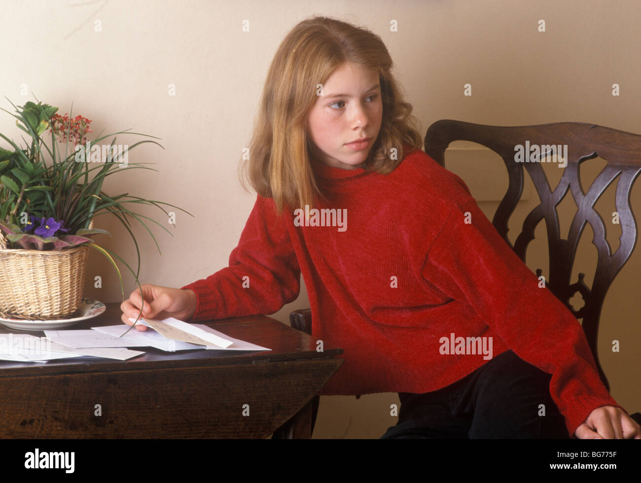 girl looking furtive as she reads her mother's letter Stock Photo - Alamy