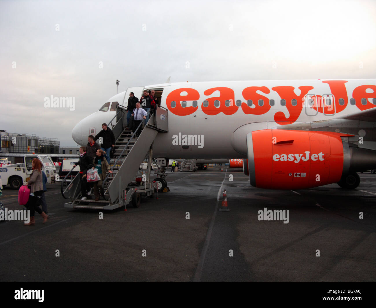 passengers disembarking easyjet aircraft under dull grey skies at ...