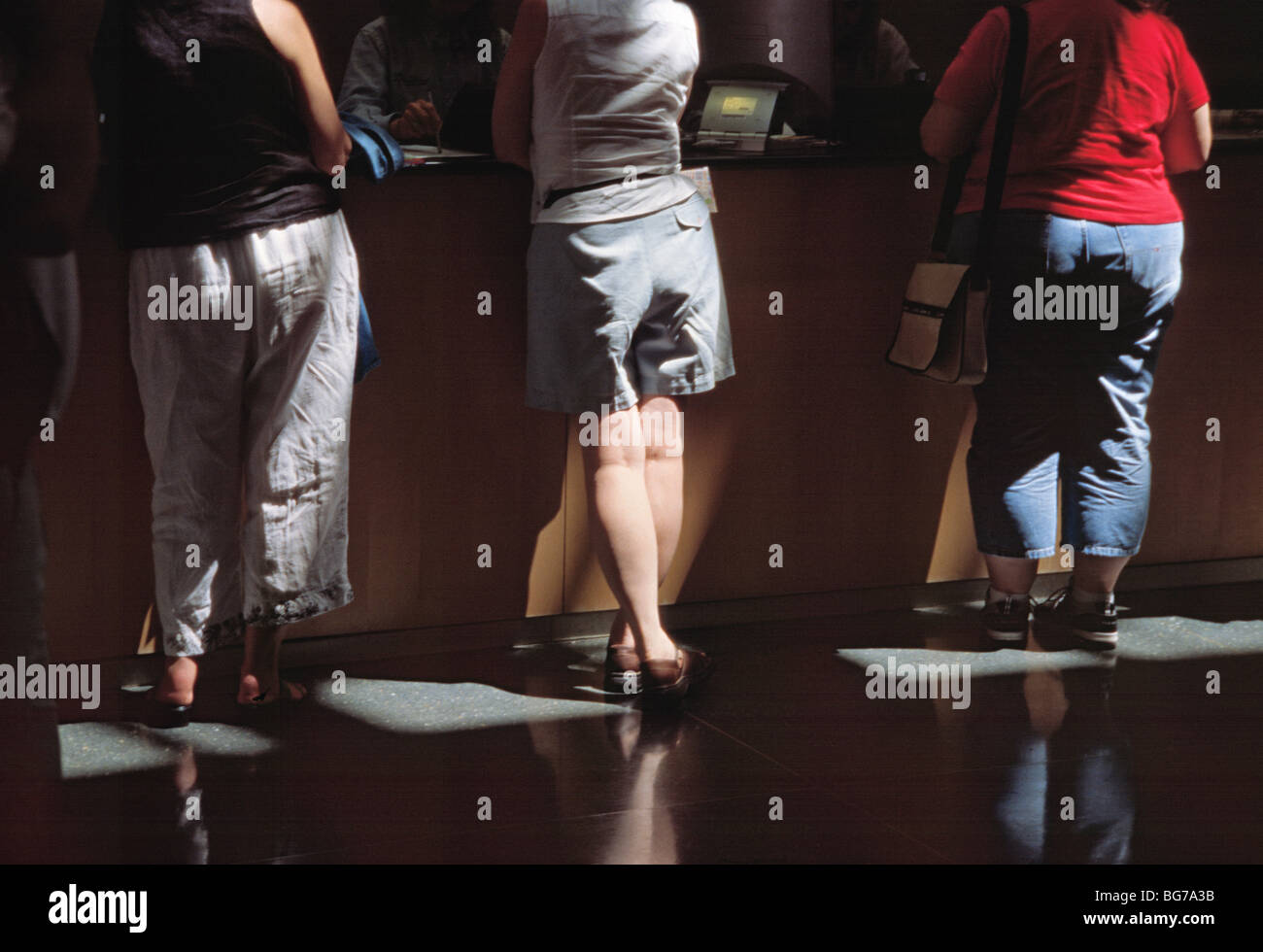 Three tourist sat information counter Stock Photo - Alamy