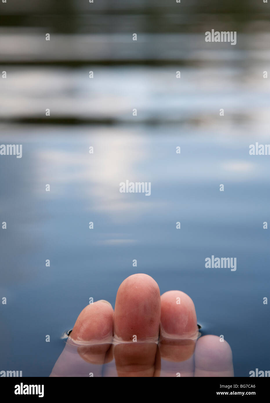 Fingertips emerging to water surface Stock Photo - Alamy