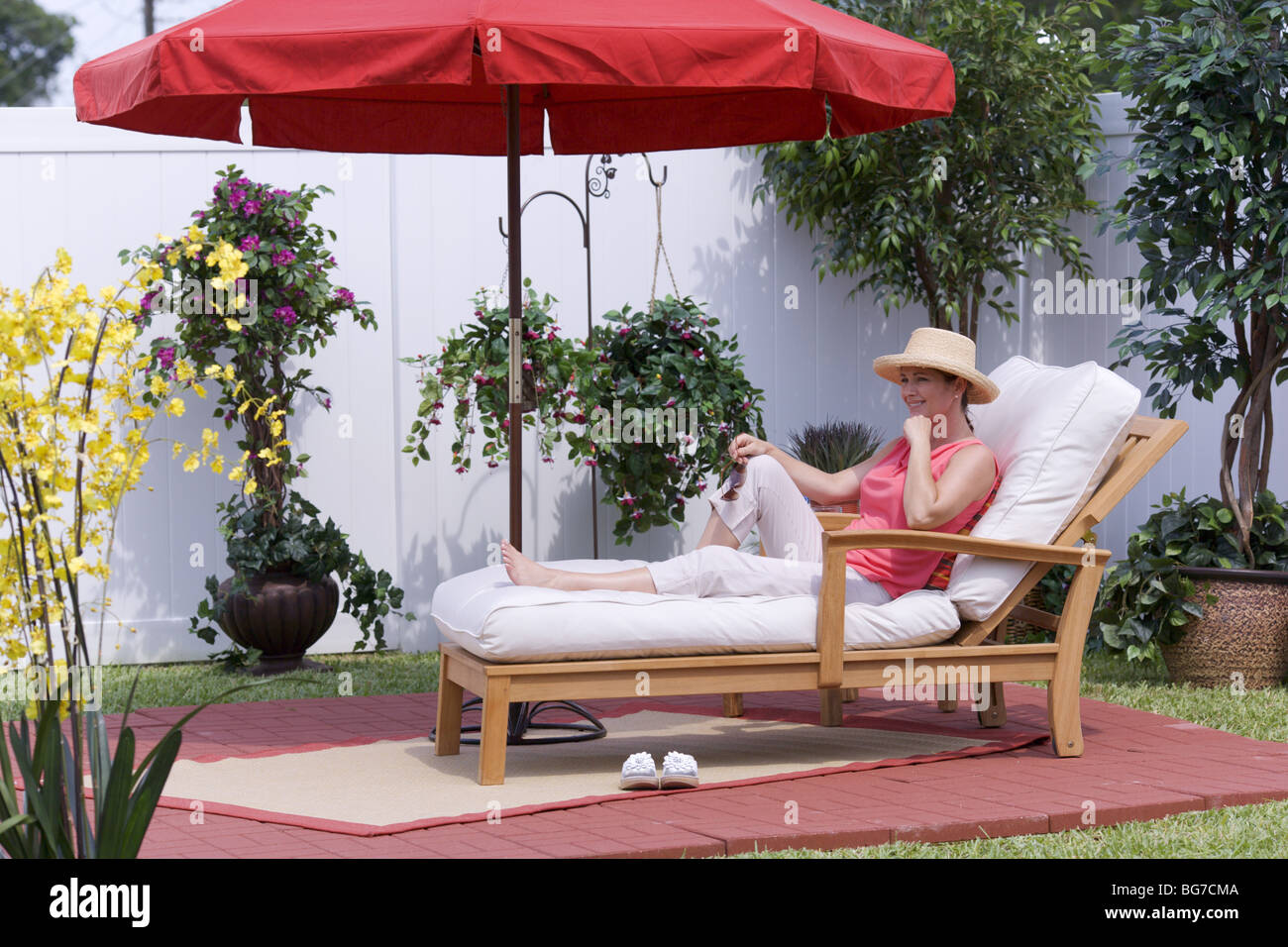 Young woman relaxing on outside deck, patio Stock Photo - Alamy
