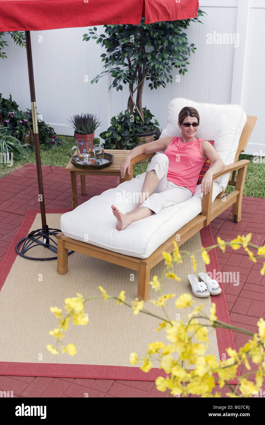 Young woman relaxing on outside deck, patio Stock Photo - Alamy