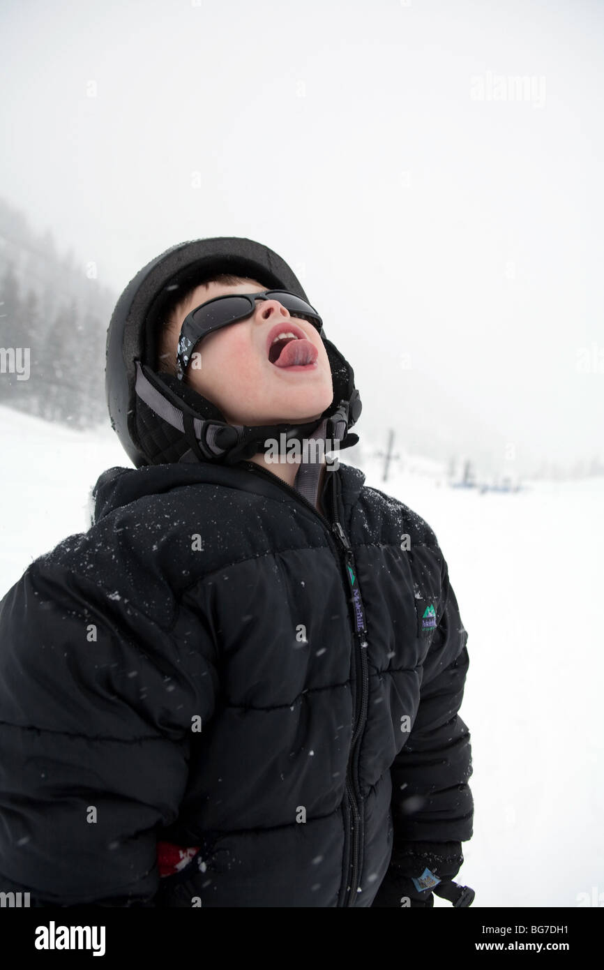 a young boy catching snowflakes on tongue Stock Photo - Alamy