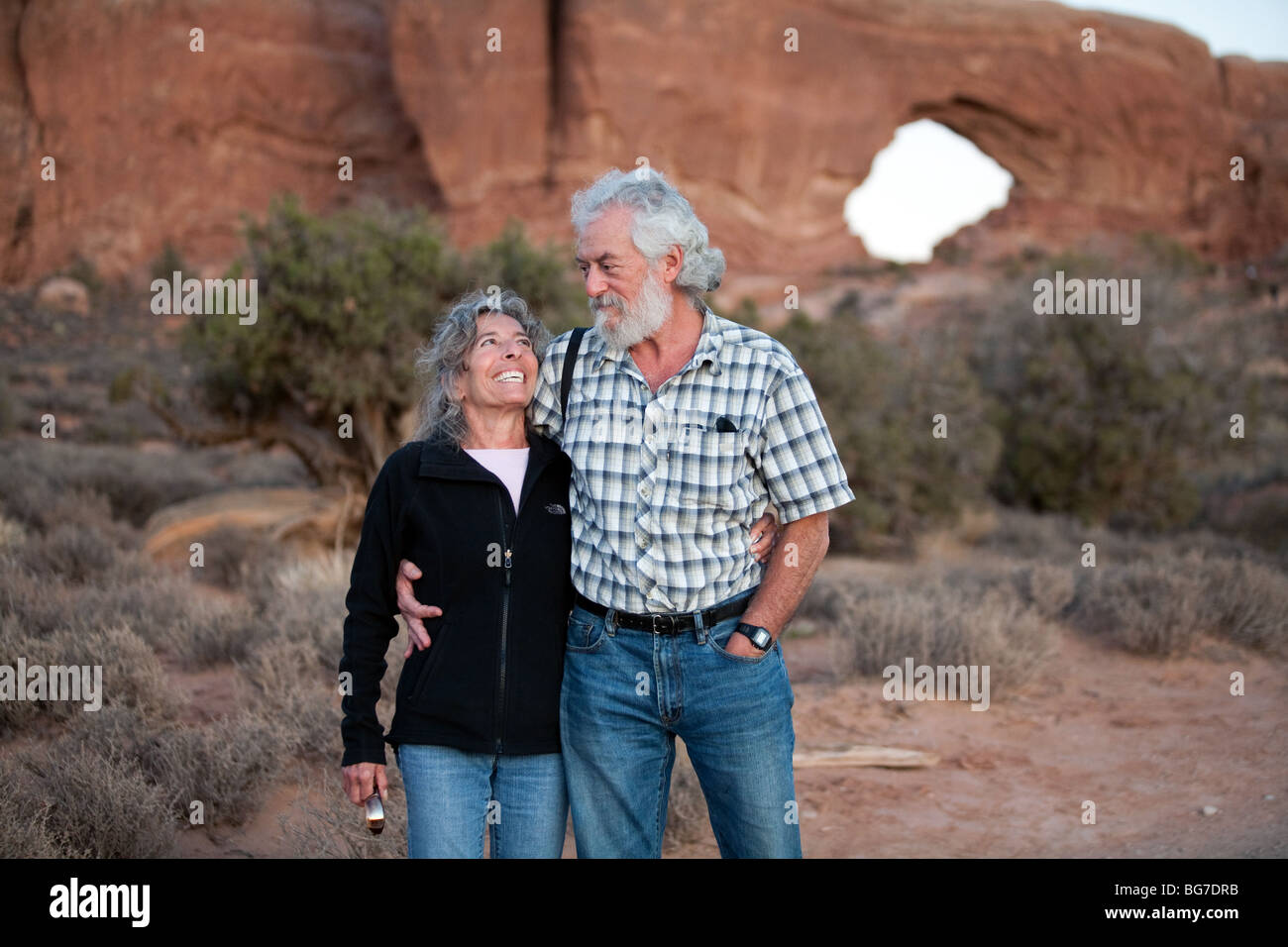 Two senior citizens embrace at Arches National Park in Moab, UT Stock ...