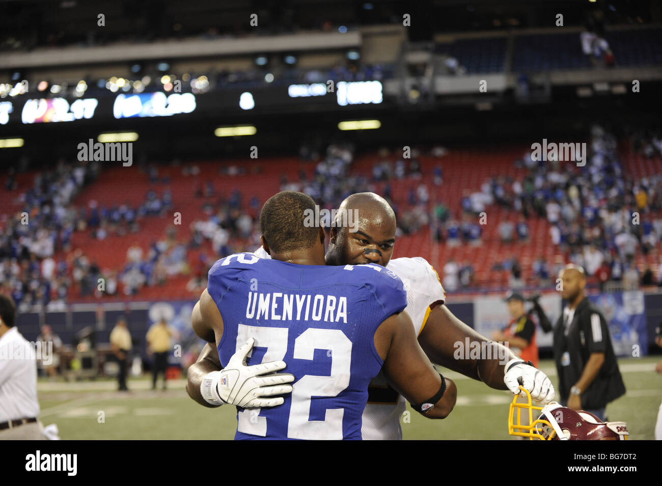 Two football players from opposing teams embrace at the completion of ...