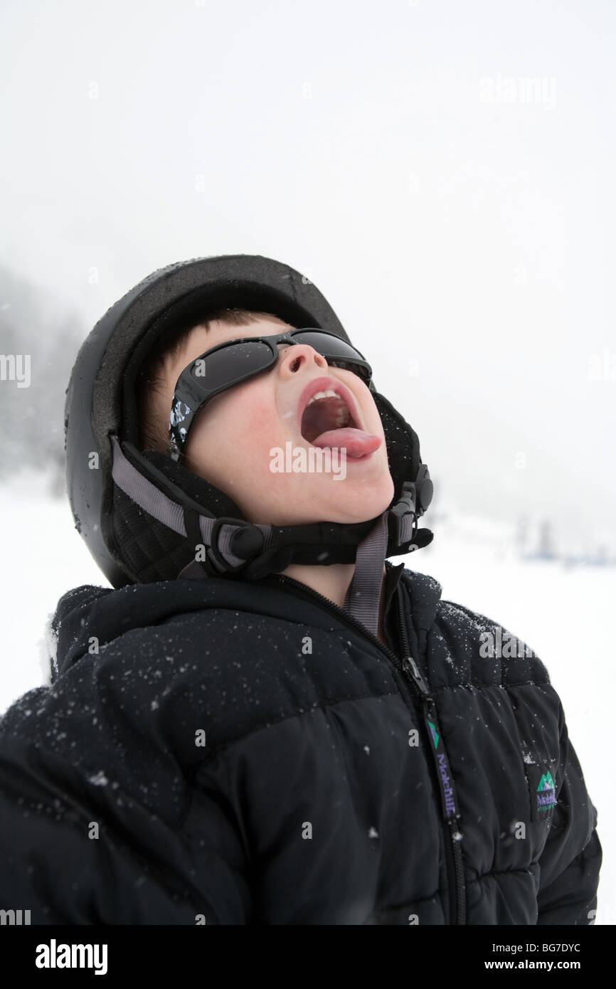 a young boy catching snowflakes on tongue Stock Photo - Alamy