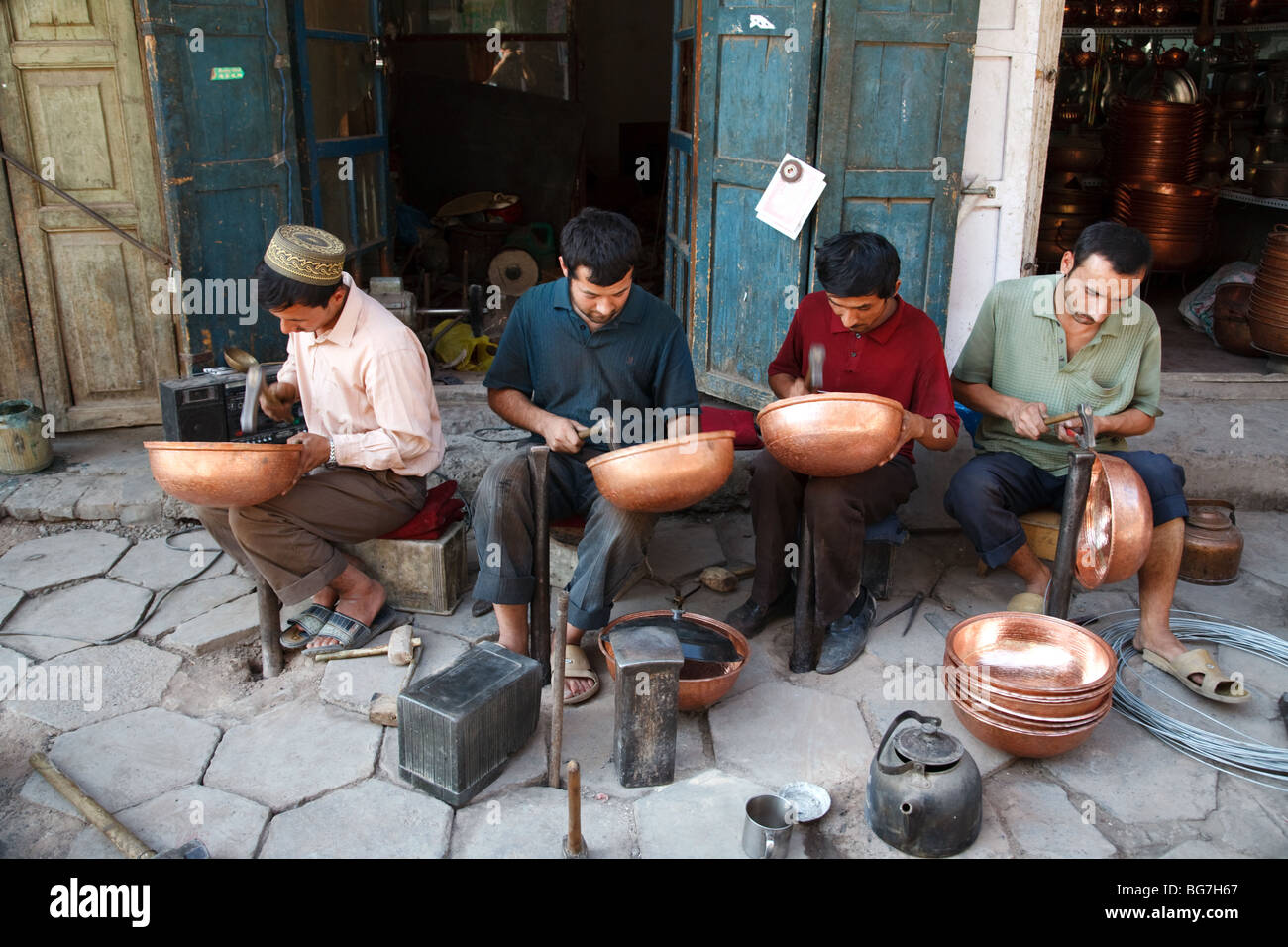 A traditional copper workshop in the Old Town of Kashgar, Xinjiang ...