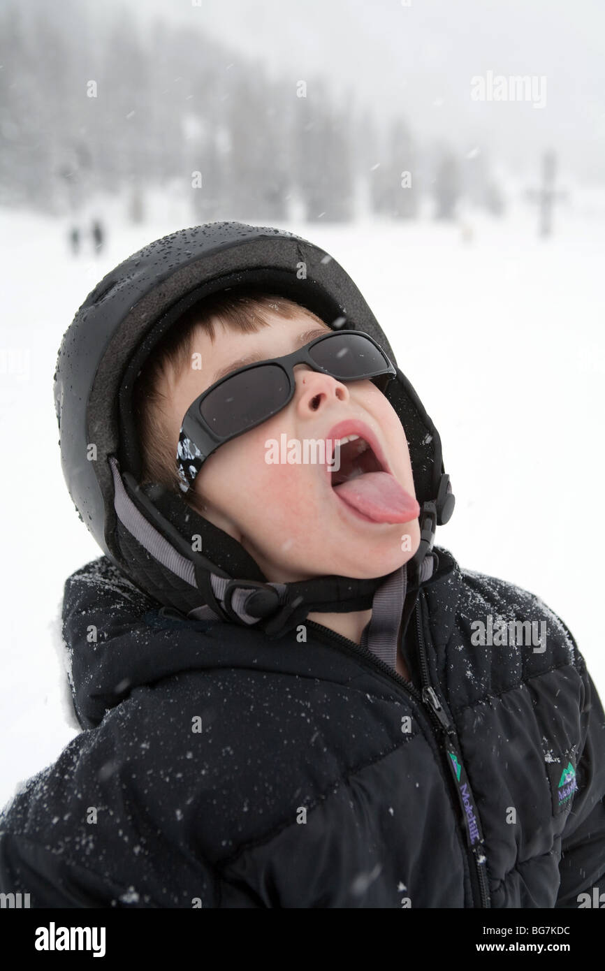 a young boy catching snowflakes on tongue Stock Photo - Alamy