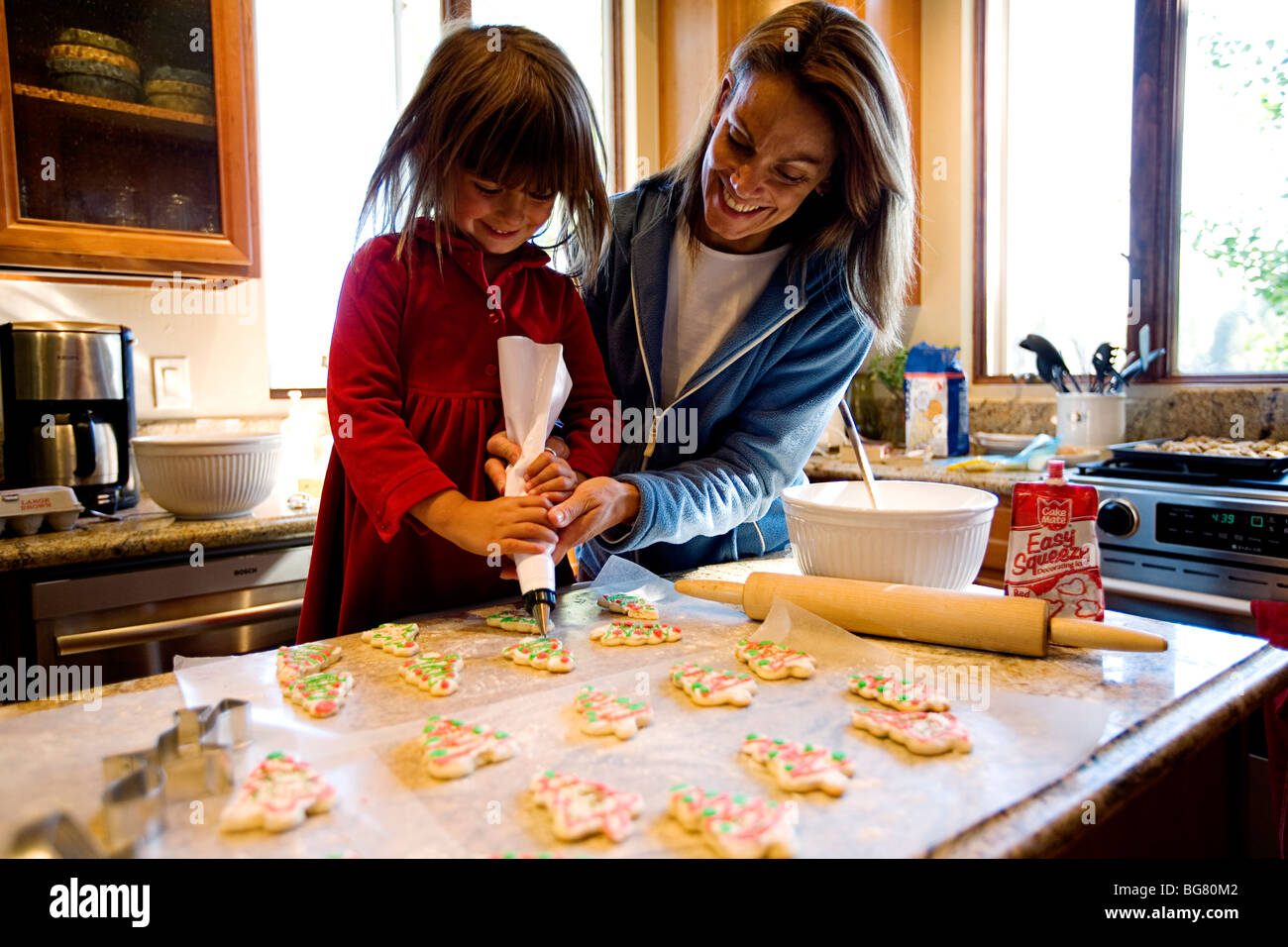Attractive woman baking Christmas cookies with her daughter Stock Photo ...