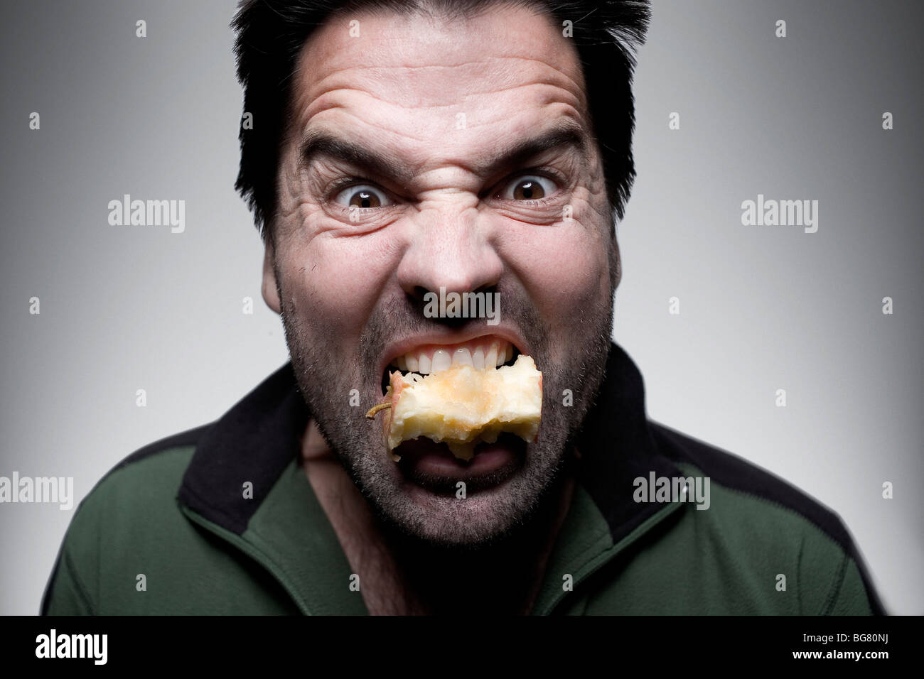 A man holds an apple core in his mouth, San Diego, California Stock ...