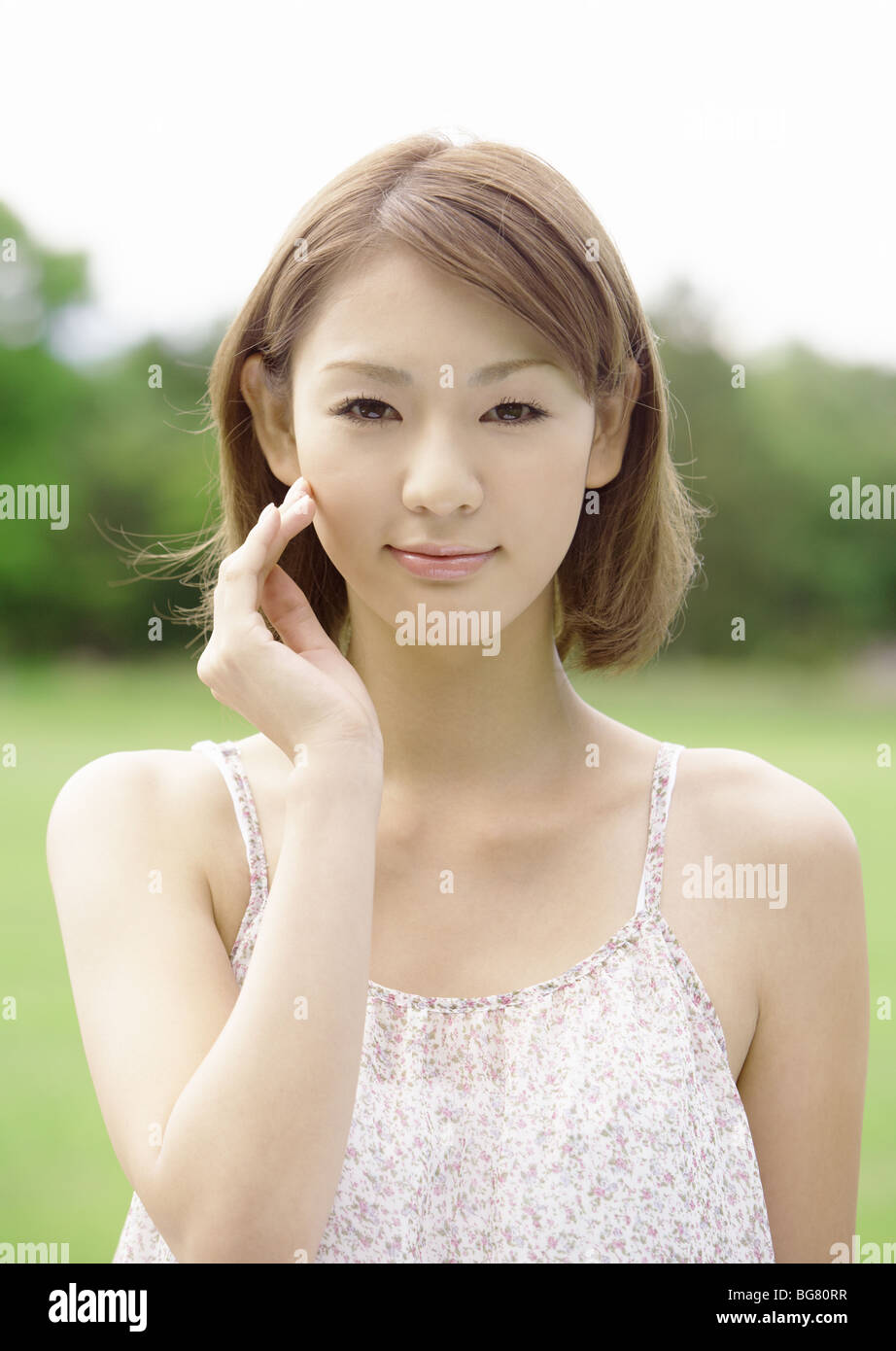 A young woman taking her cheek in her hand Stock Photo - Alamy