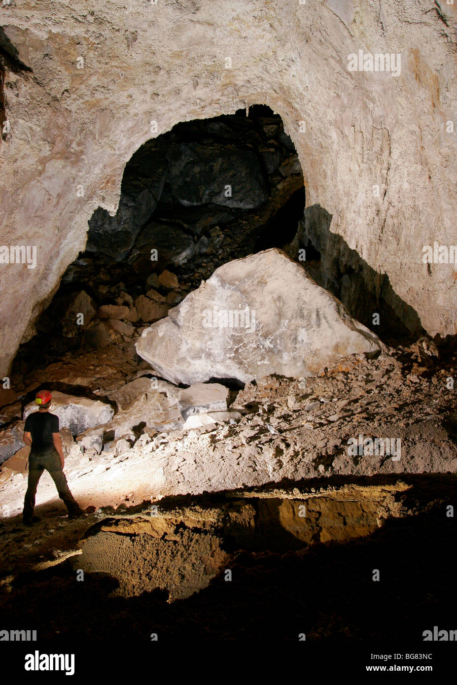 A cave explorer adds scale to a large fossil passage deep underground ...