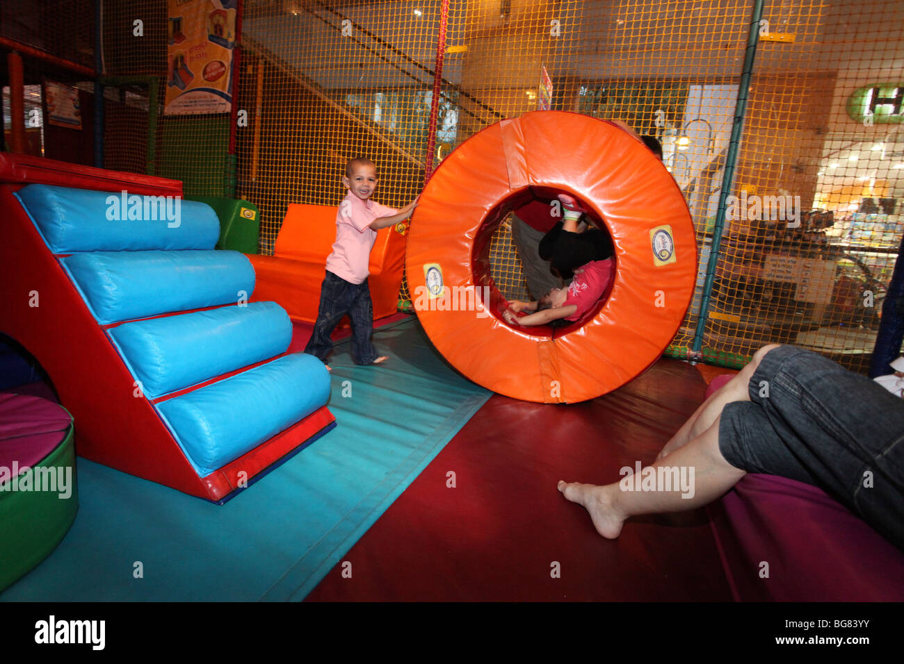 Indoor children's playground child rolls in a tube Stock Photo - Alamy