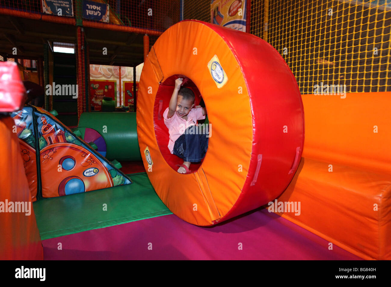 Indoor children's playground child rolls in a tube Stock Photo - Alamy