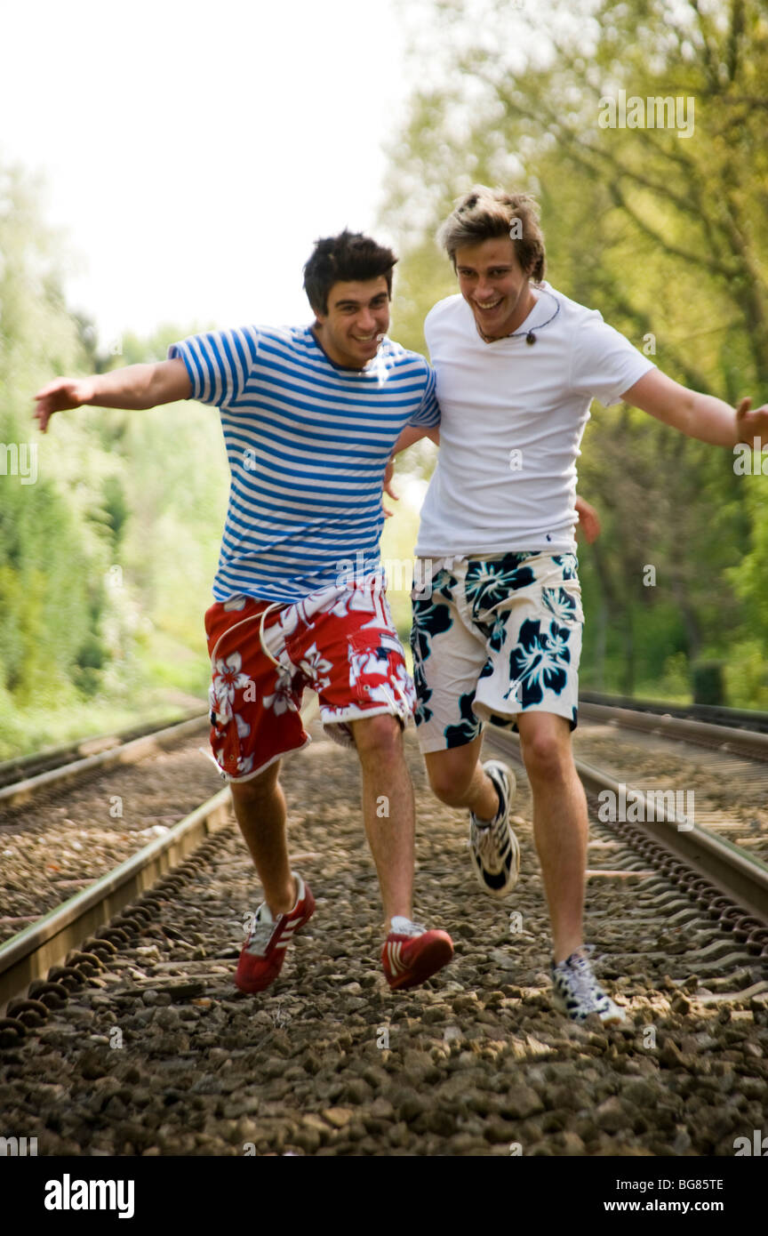 2 teenage boys running along a railway track Stock Photo - Alamy