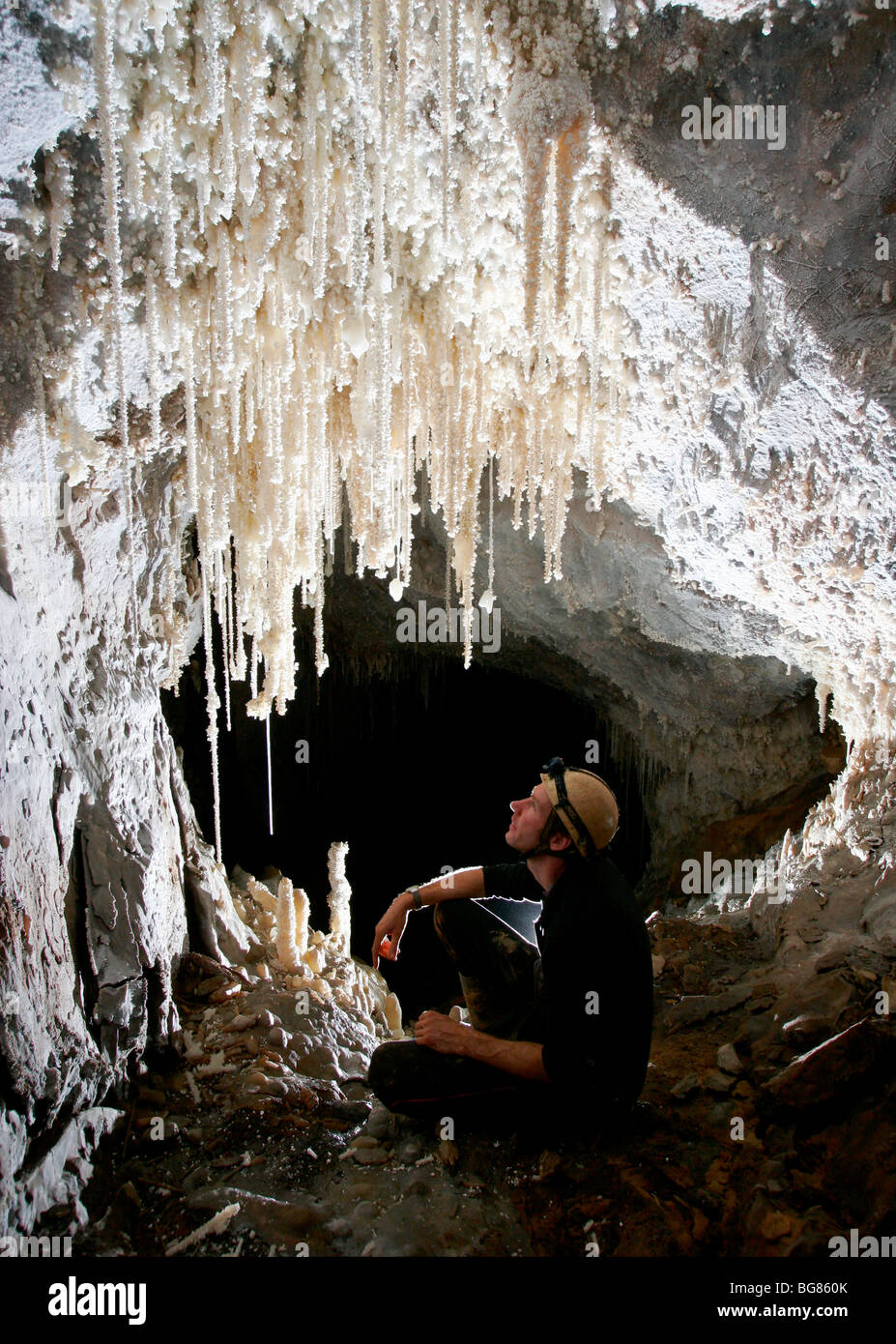 A cave explorer admires delicate Stalactite formations clinging to the ...