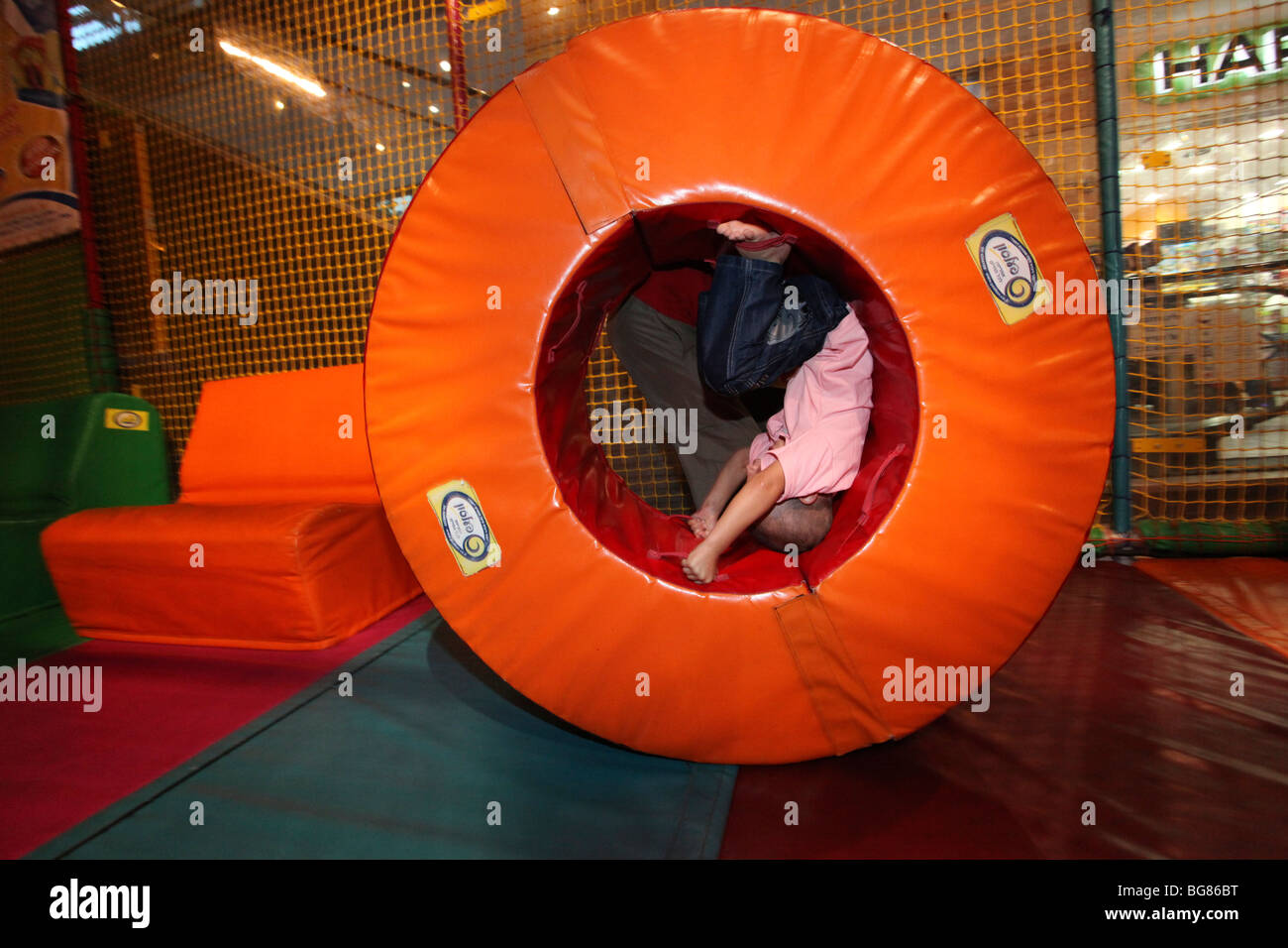 Indoor children's playground child rolls in a tube Stock Photo - Alamy