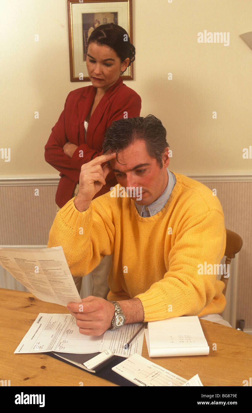 man looking anxious and stressed over bills with his ethnic partner in ...