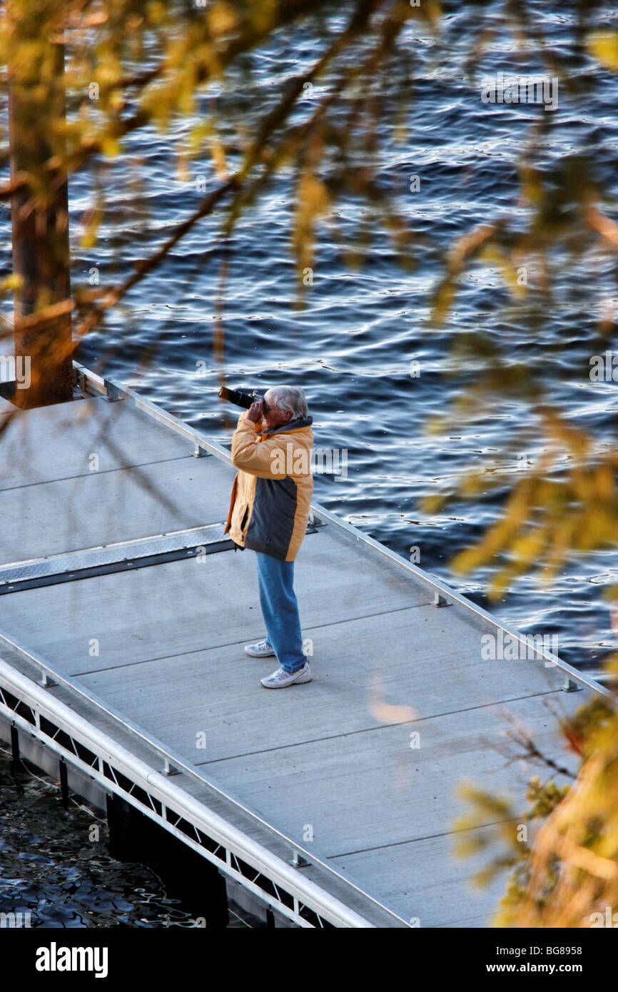Wildlife photographer on a dock on Lake Coeur D Alene, Idaho, at ...