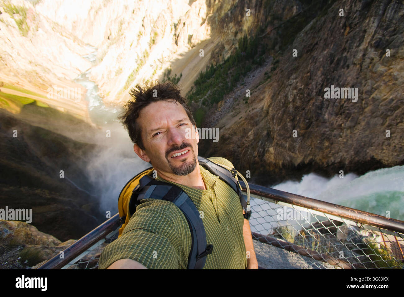 A self portrait of a man standing at a overlook above Yellowstone Falls ...