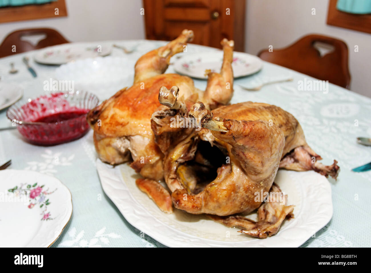 Two roasted chickens set on dining table Stock Photo - Alamy