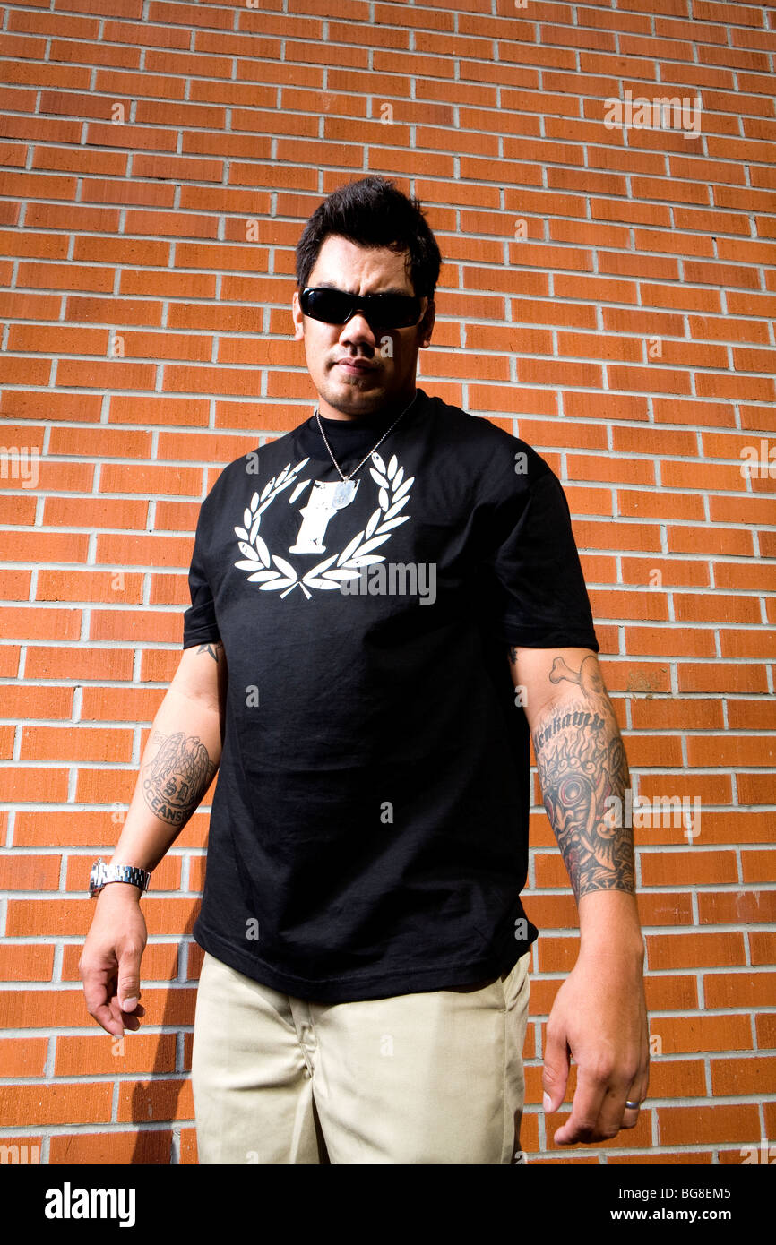 Tough guy standing against a brick wall Stock Photo - Alamy