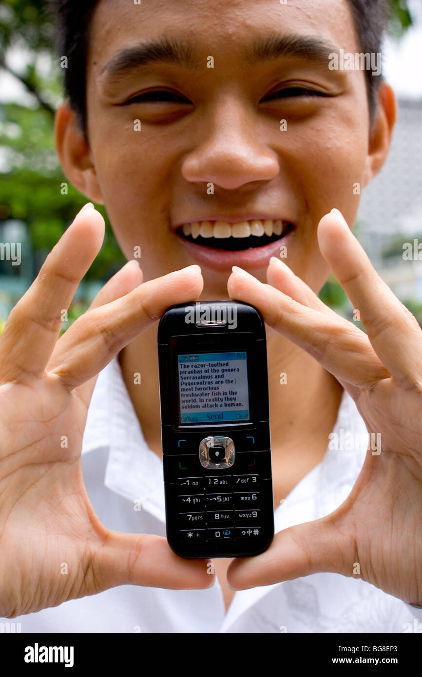 A young man poses with his mobile phone in Singapore Stock Photo - Alamy