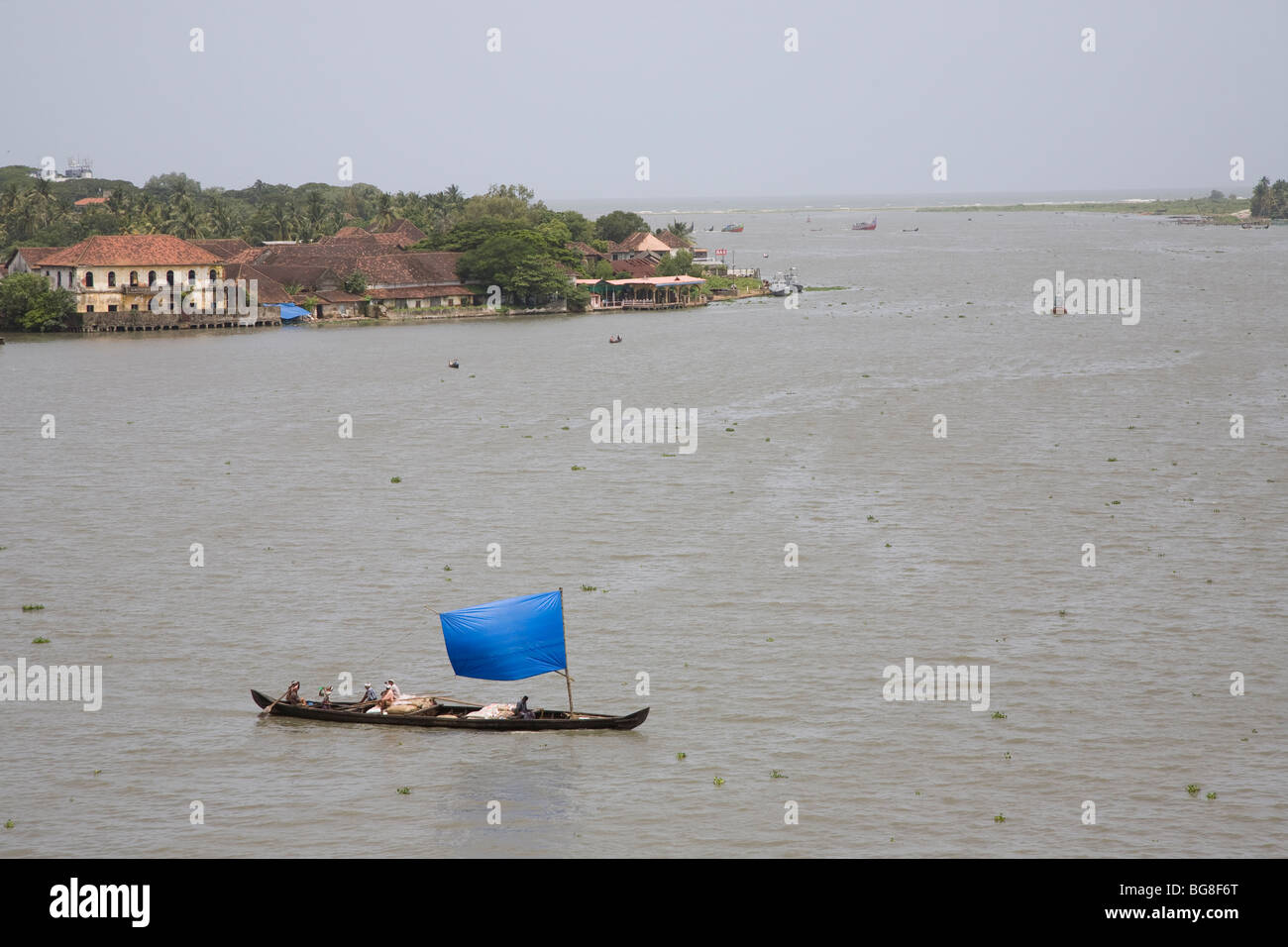 Small sailboat with blue tarp sail crosses waterway Stock Photo - Alamy