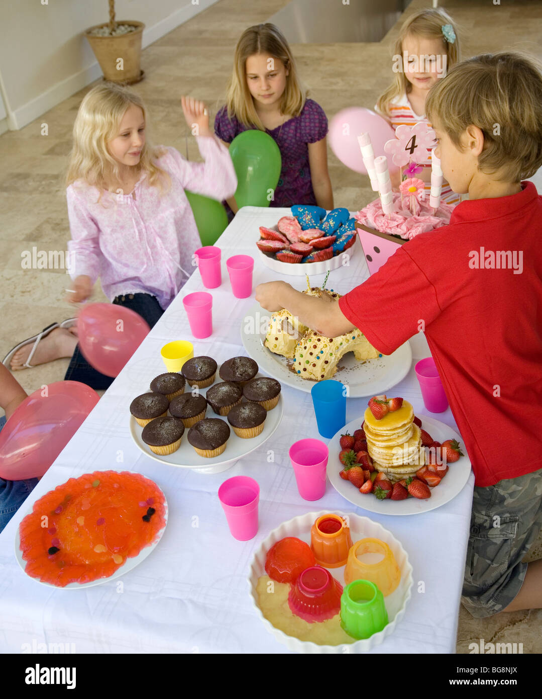 Small Children's - kids around table with sweets and cakes Stock Photo ...
