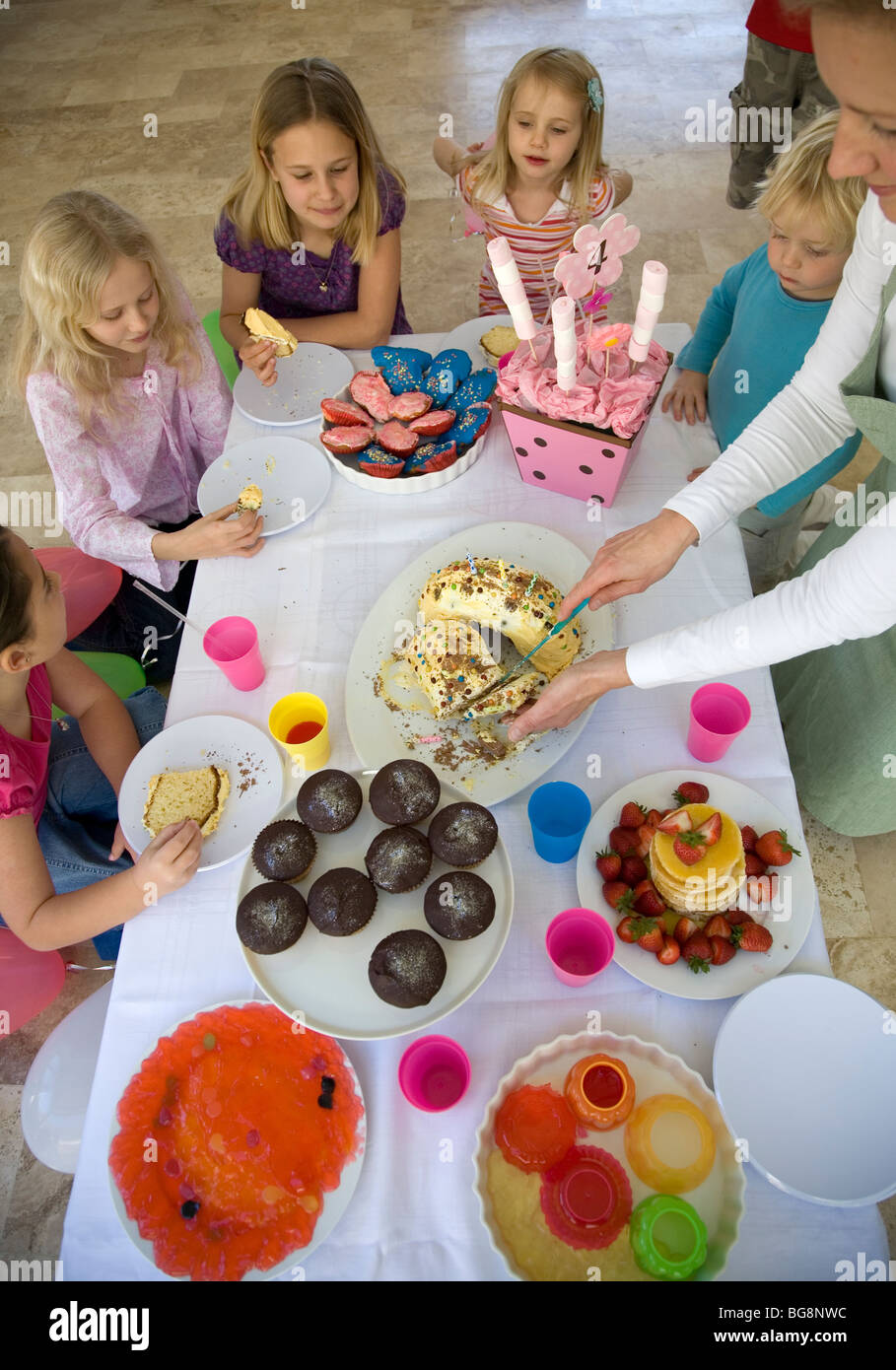 Small Children's - kids around table with sweets and cakes Stock Photo ...