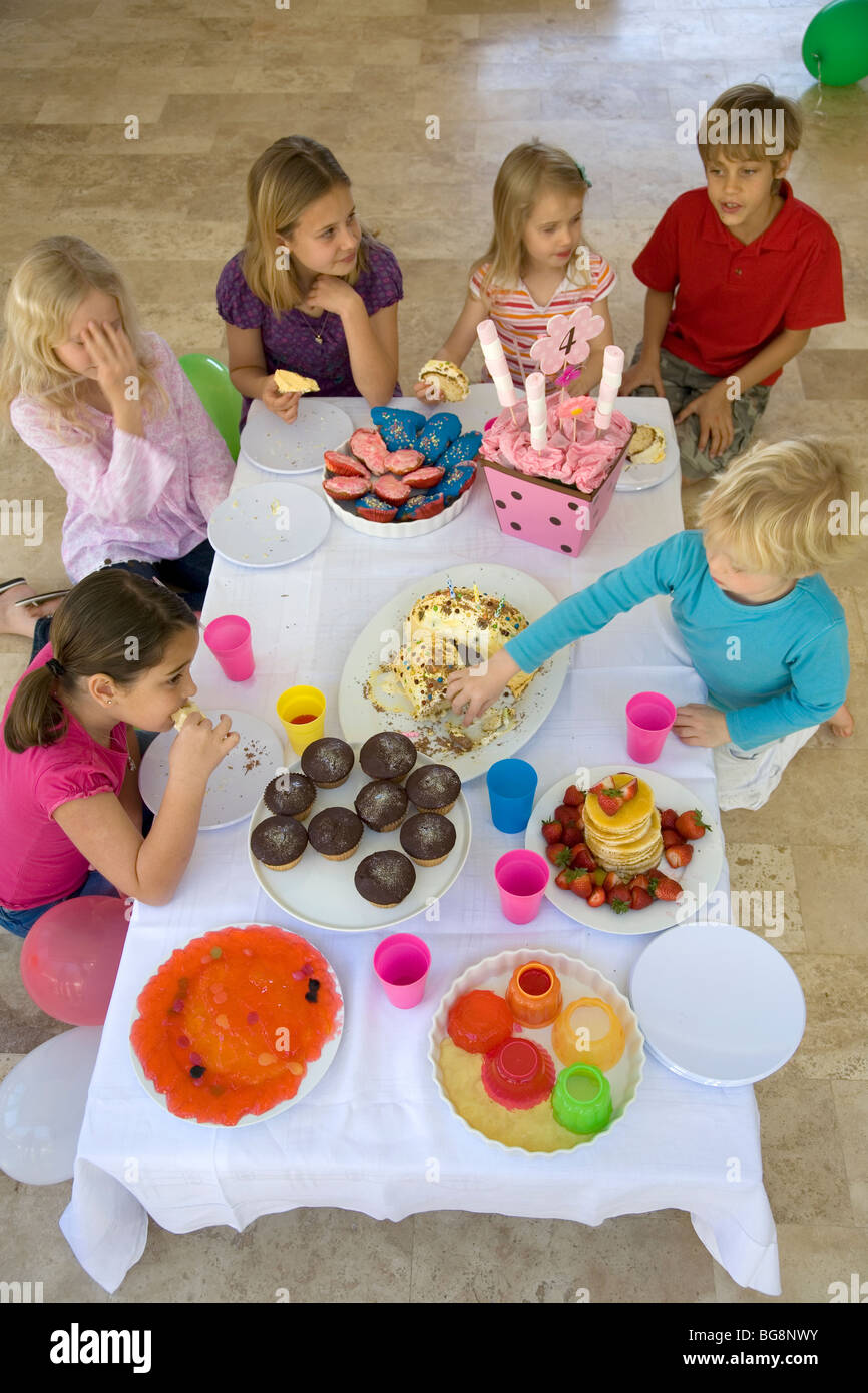 Small Children's - kids around table with sweets and cakes Stock Photo ...
