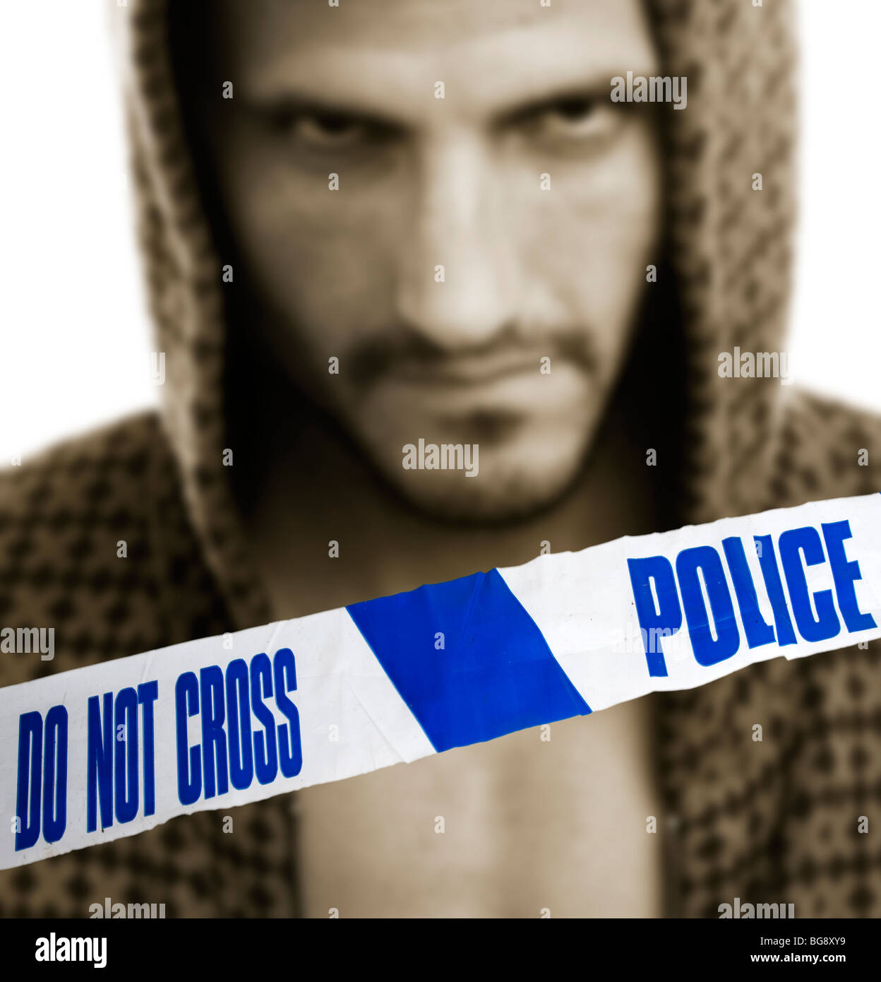 man wearing a hooded top behind police barrier Stock Photo - Alamy