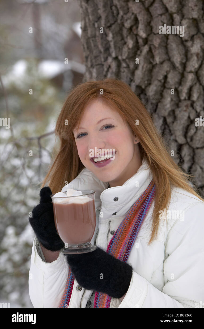 Girl drinking hot chocolate outside in the snow Stock Photo - Alamy