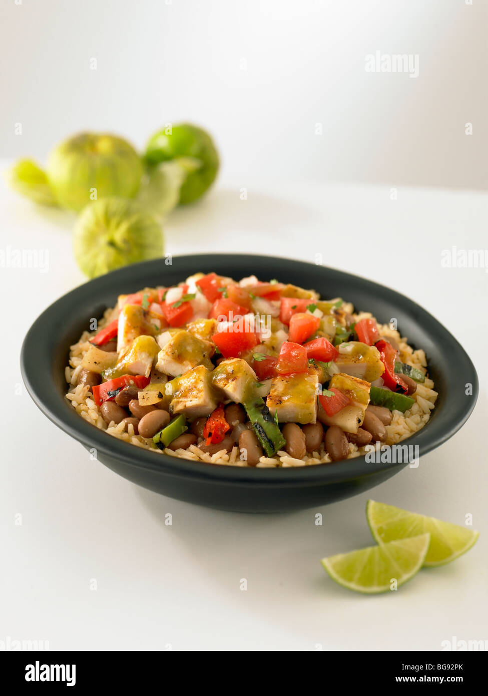Grilled chicken fajita rice bowl on white with lime and tomatillos ...