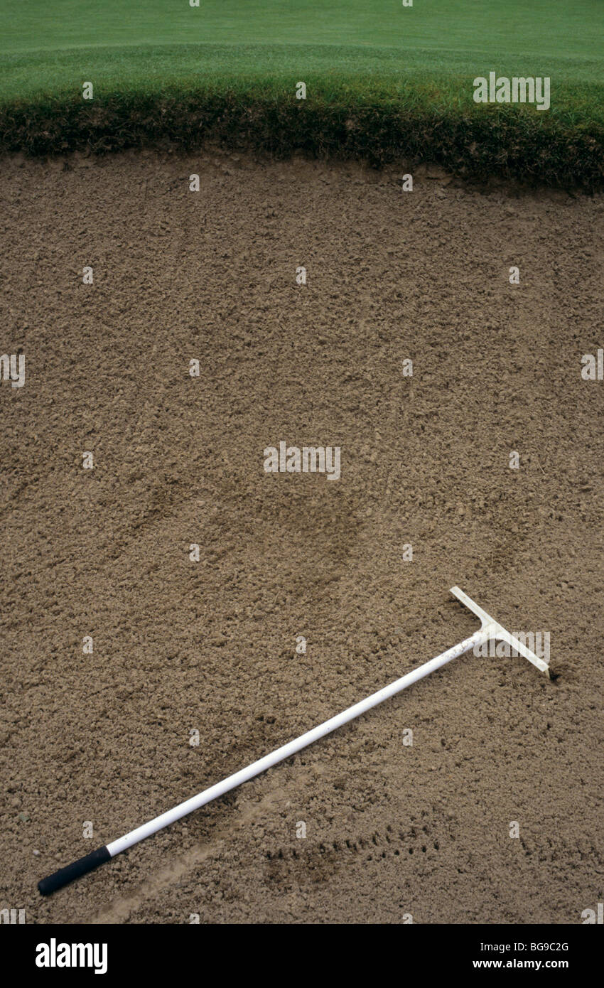 Rake in a golf course sand bunker Stock Photo - Alamy