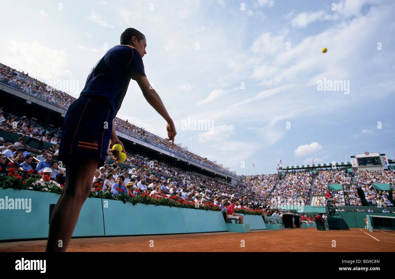 Ball boy throws a tennis ball to a player Stock Photo - Alamy