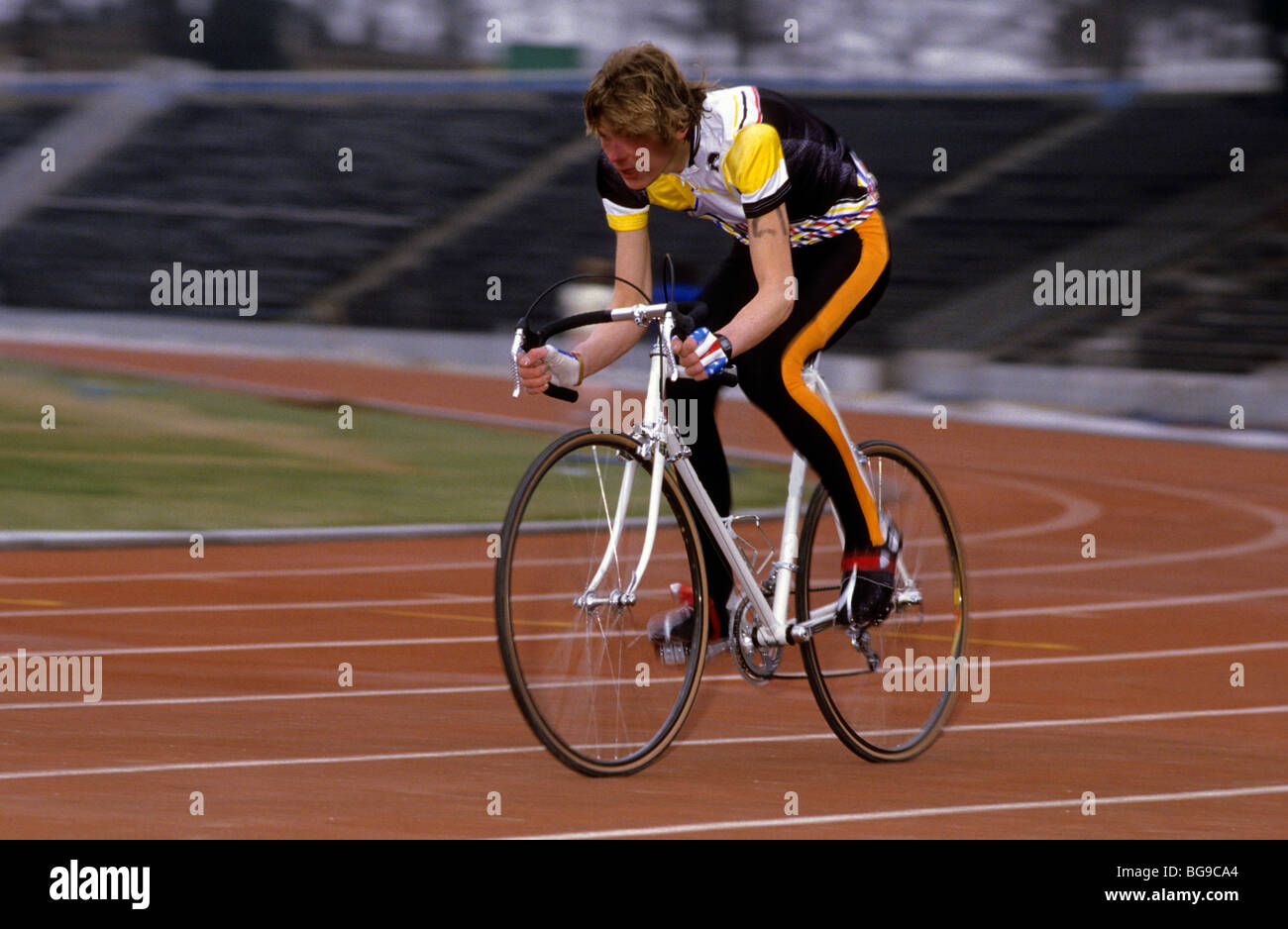 Young man riding a bicycle on an athletics track Stock Photo - Alamy