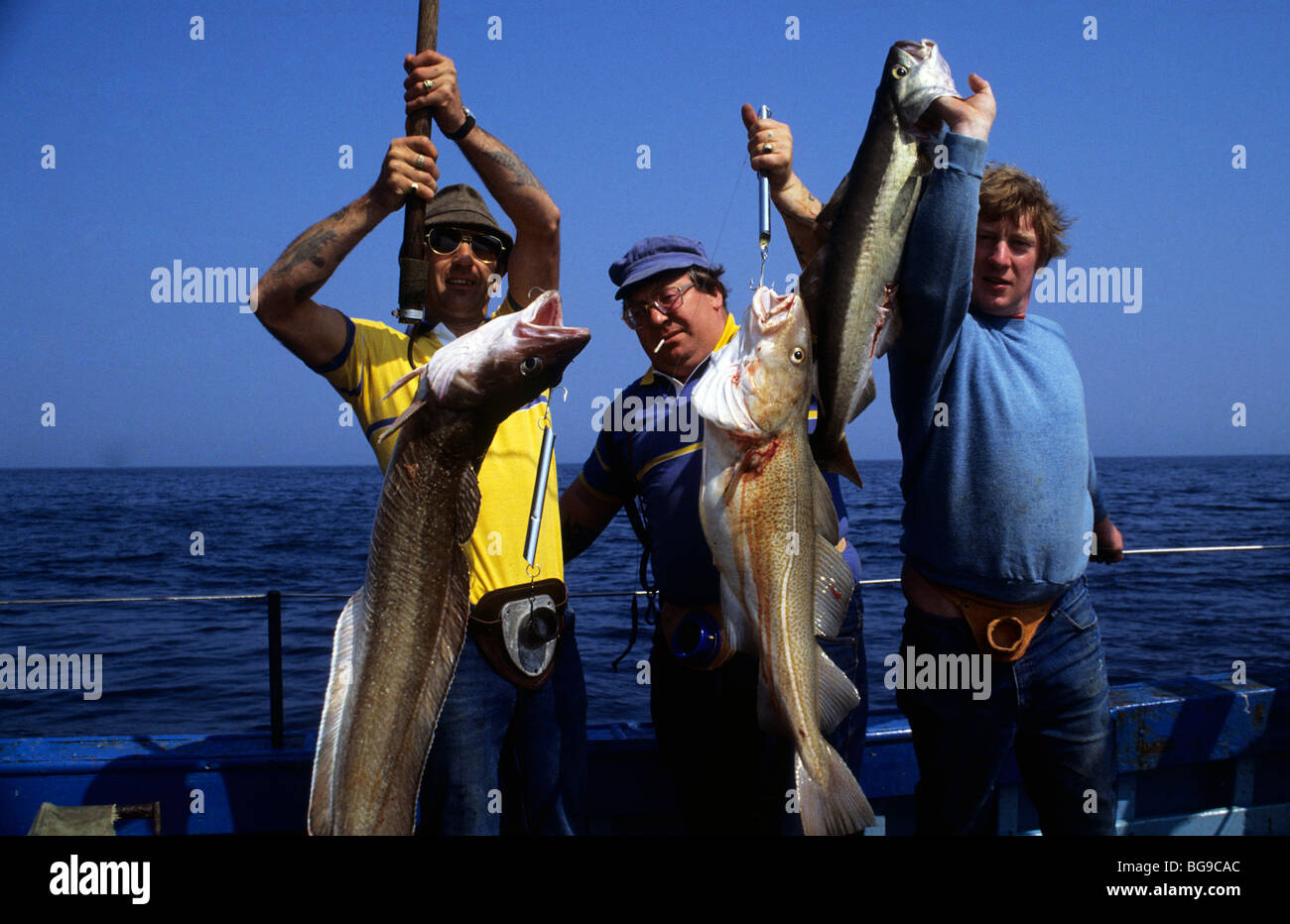 Three fishermen with their catch Stock Photo - Alamy
