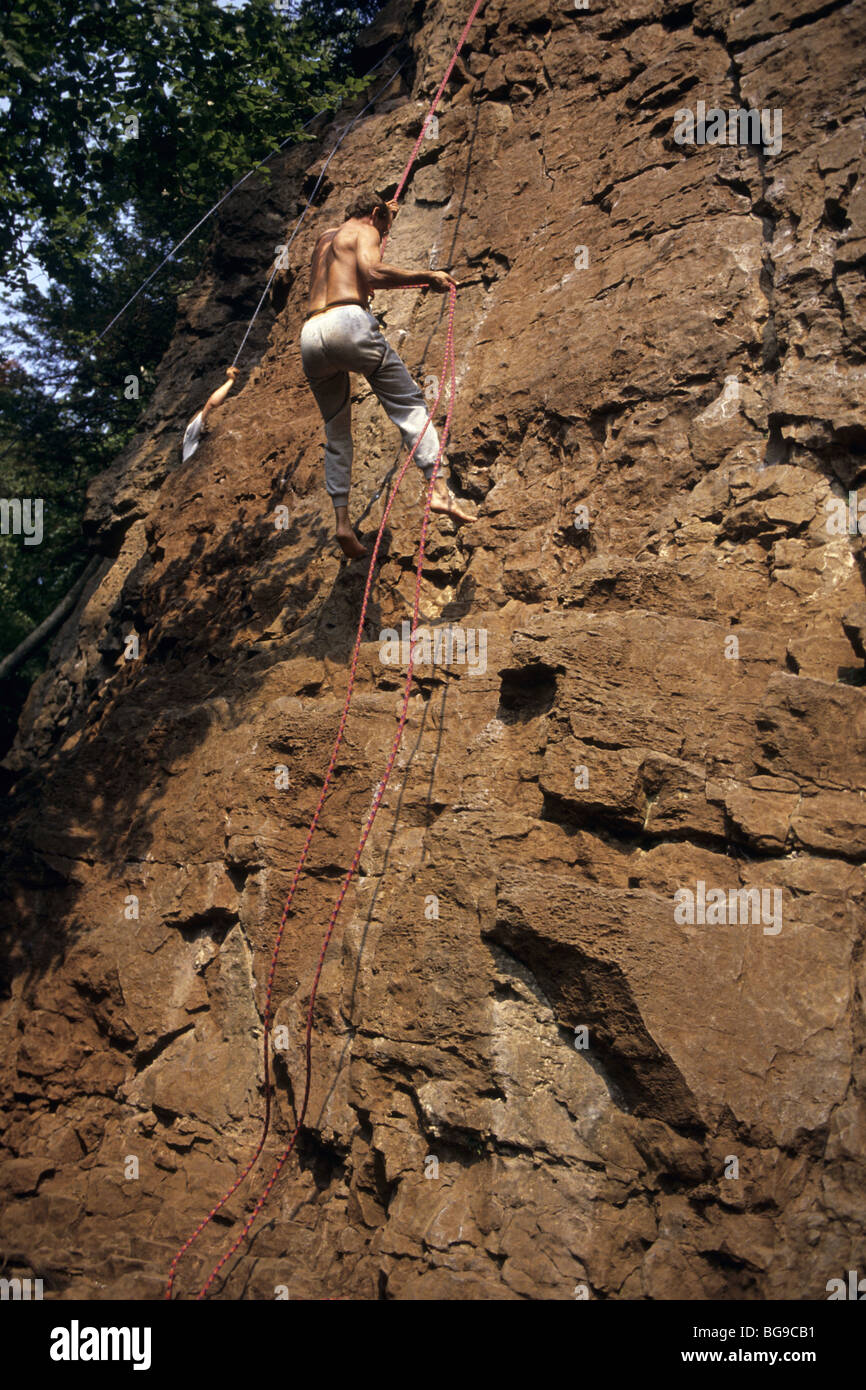 Barefoot man abseiling a rock face Stock Photo - Alamy