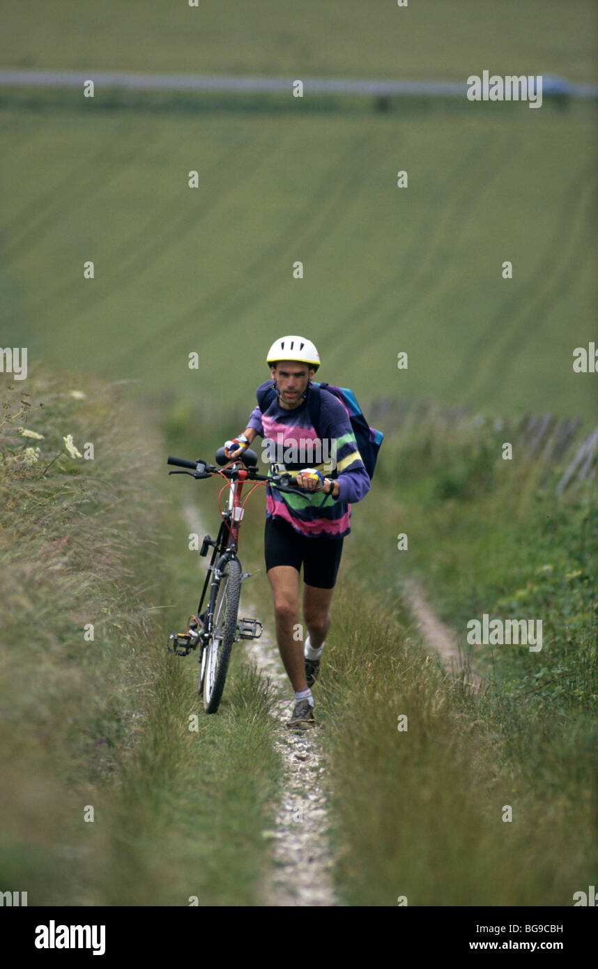 Sports cyclist walks his cycle up stony hilly pathway Stock Photo - Alamy