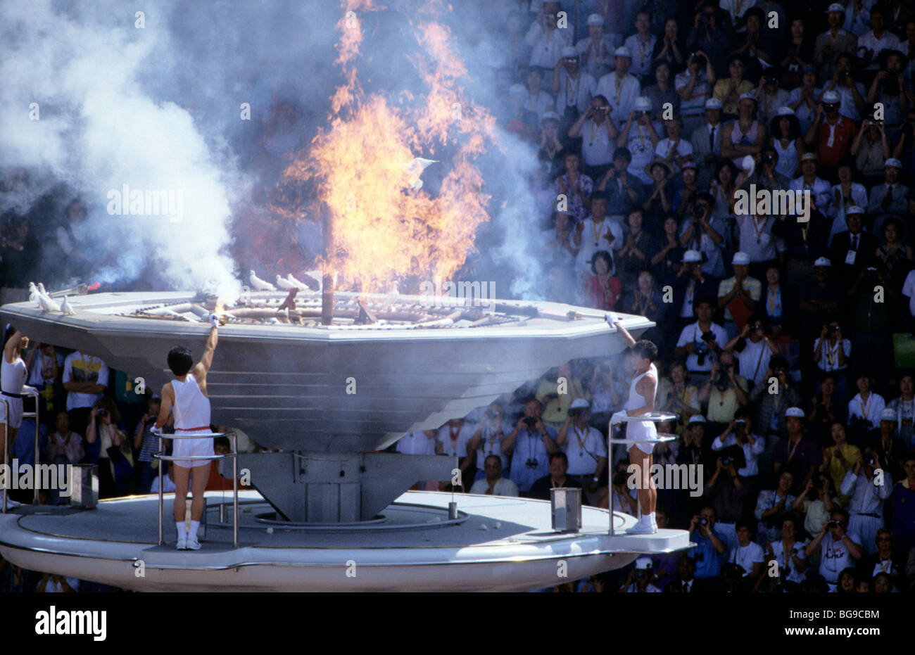 Olympic flame with crowd in background Stock Photo - Alamy