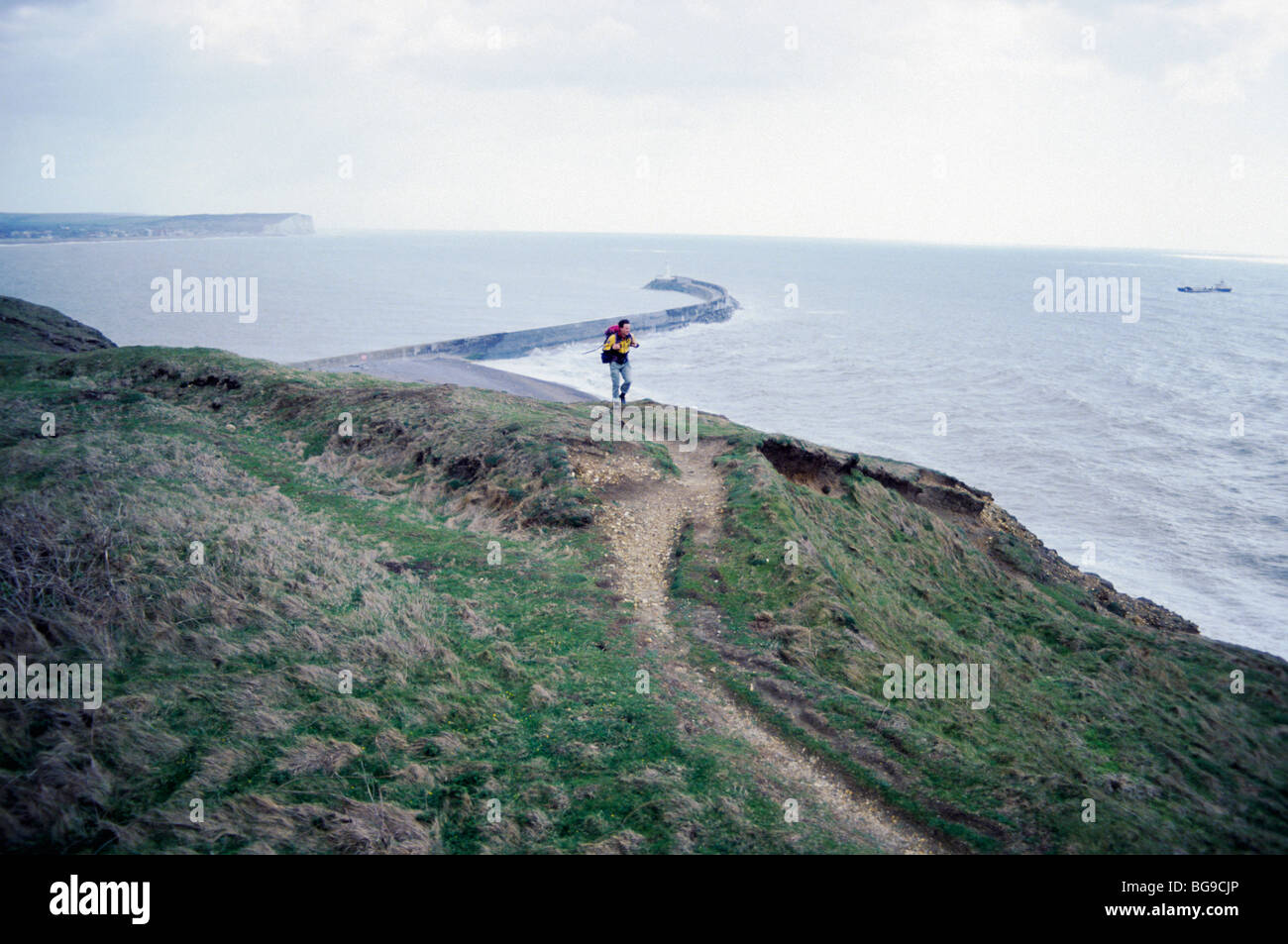Hill walker walking along a cliff top path by the sea Stock Photo - Alamy