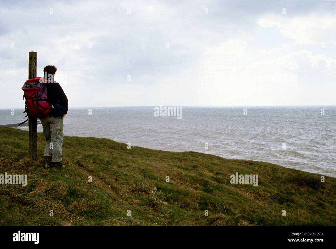 Hill walker on cliff top path by the sea Stock Photo - Alamy