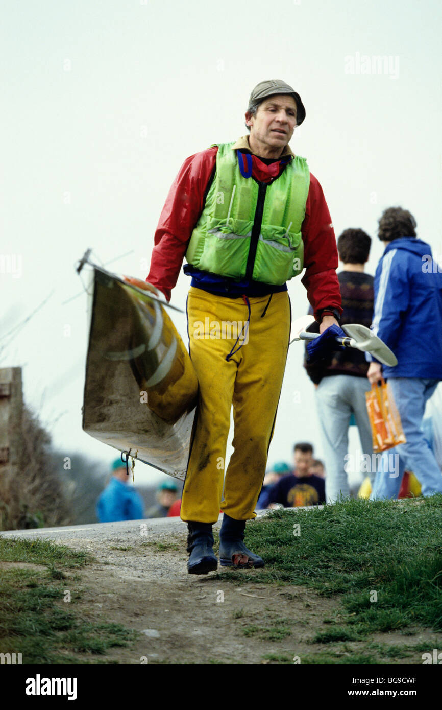 Man carrying a kayak along a rural path Stock Photo - Alamy