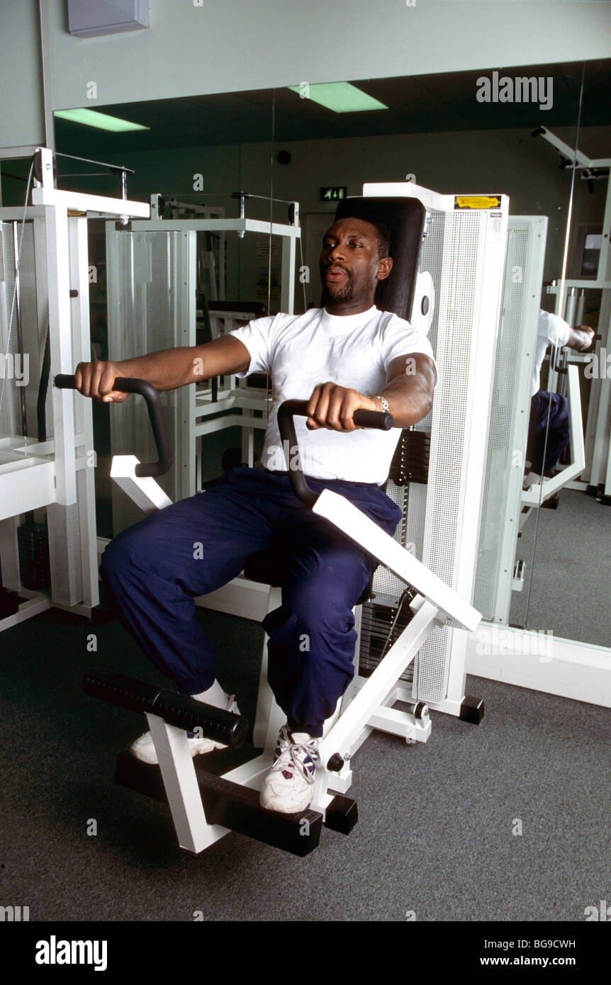 Man working on a fitness machine in a gym Stock Photo - Alamy