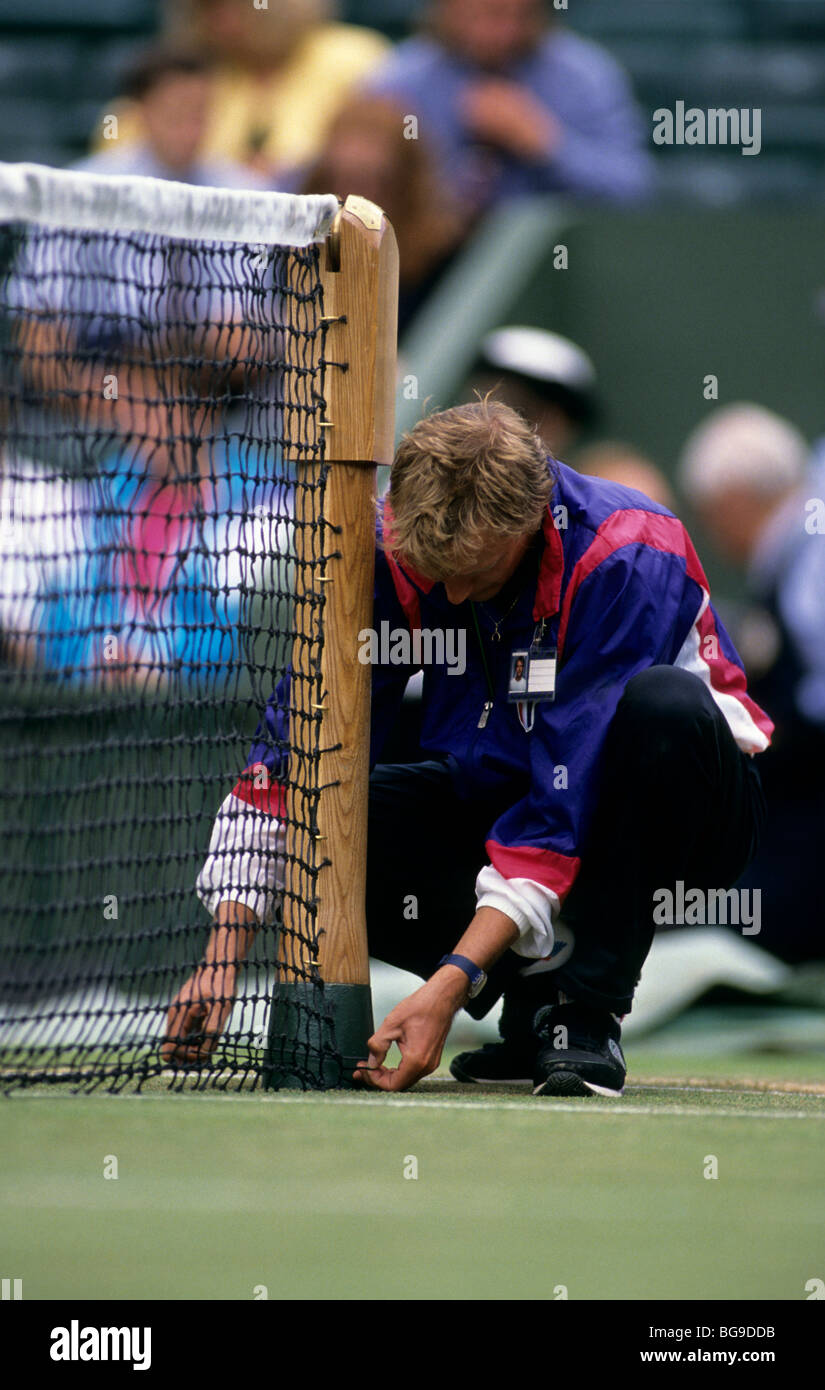 Official setting up a tennis court net Stock Photo - Alamy