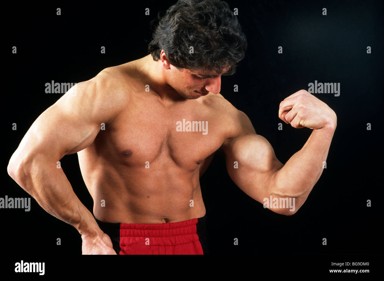 Body builder posing to show muscle definition Stock Photo - Alamy