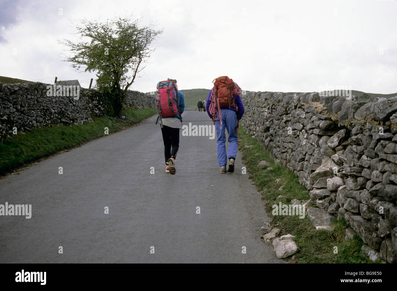 Man and woman walking along a country lane Stock Photo - Alamy