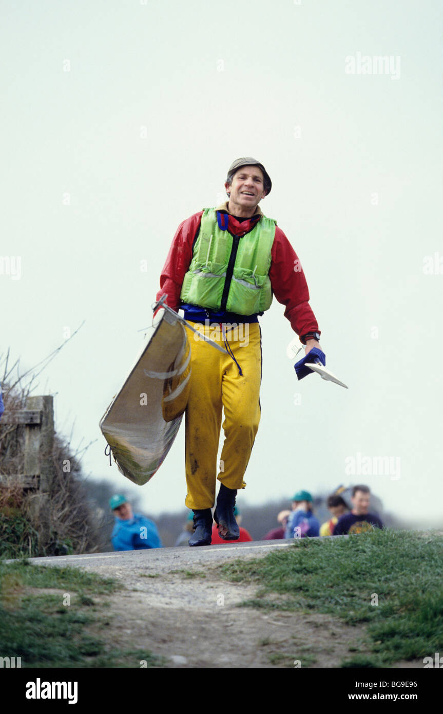 Man carrying a kayak along a rural path Stock Photo - Alamy