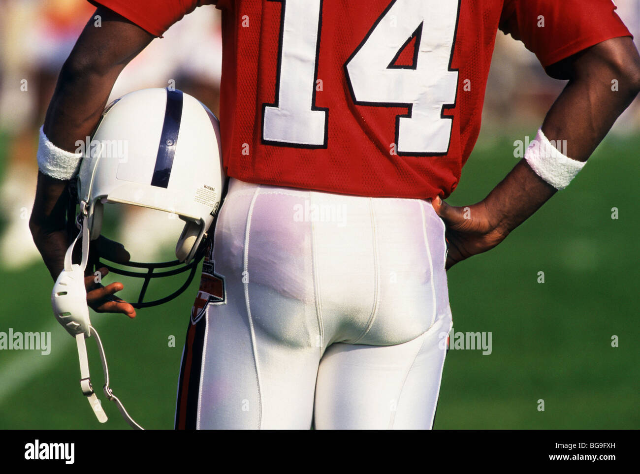 Close up of the back of an American Football player holding his helmet ...